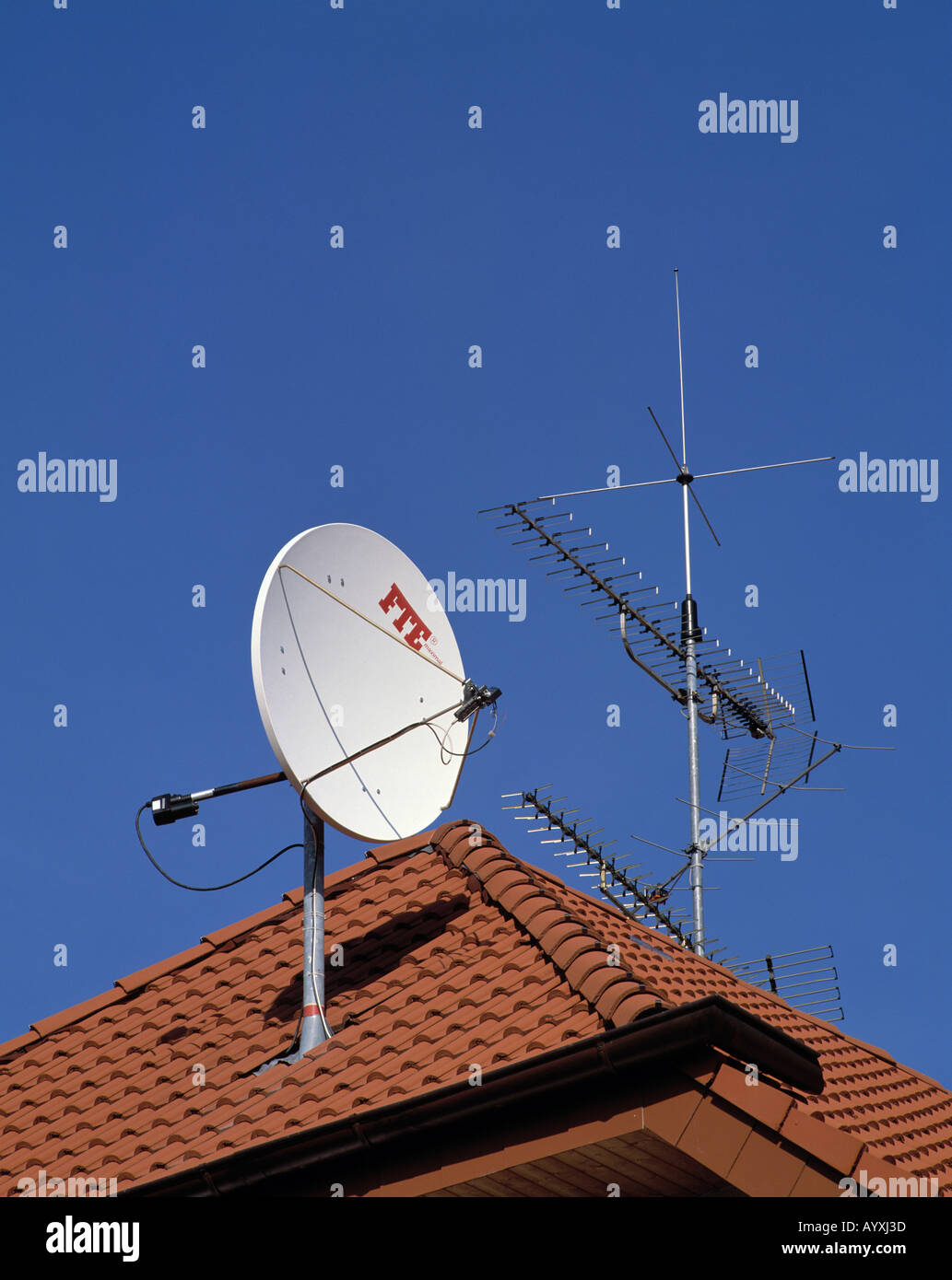 Parabolantenne und konventionelle Antenne auf einem Hausdach Stock ...