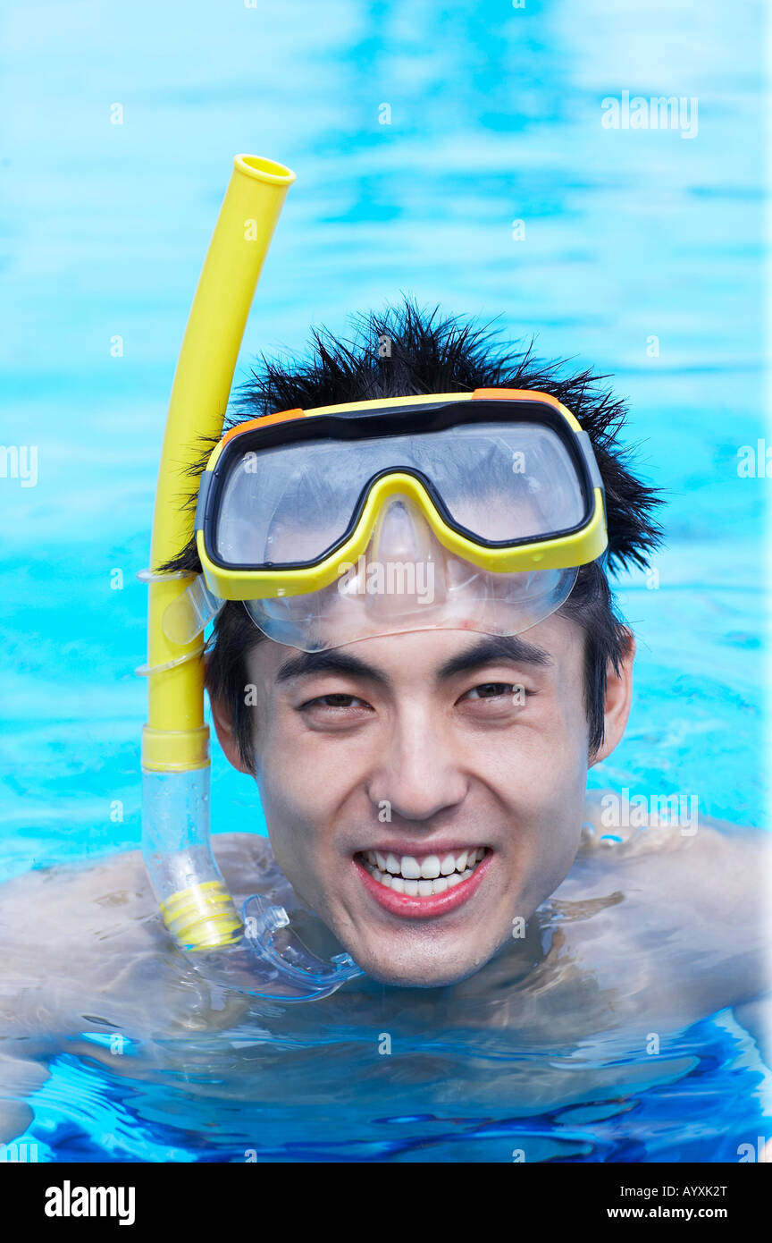 a man smiling with putting a scuba mask in the water of swimming pool ...