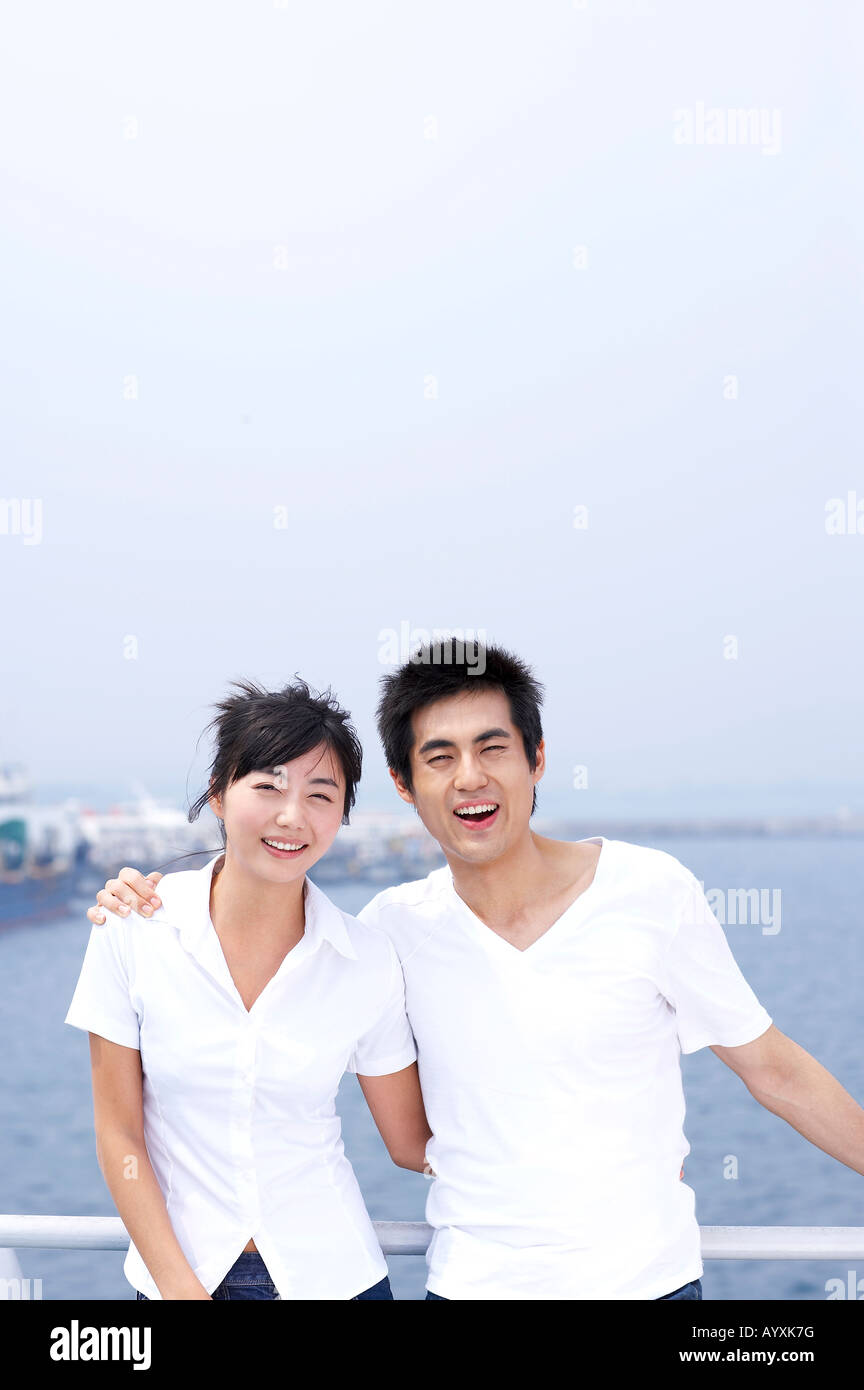 a couple smiling with putting arms around each other's shoulders in the ...