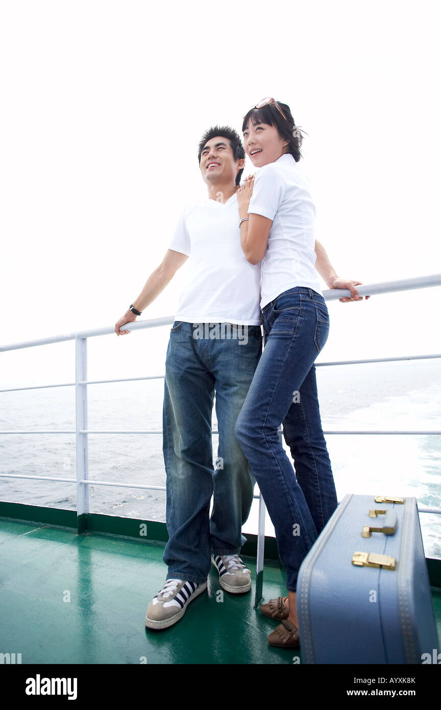 a couple smiling with leaning against the rail of a ship Stock Photo ...