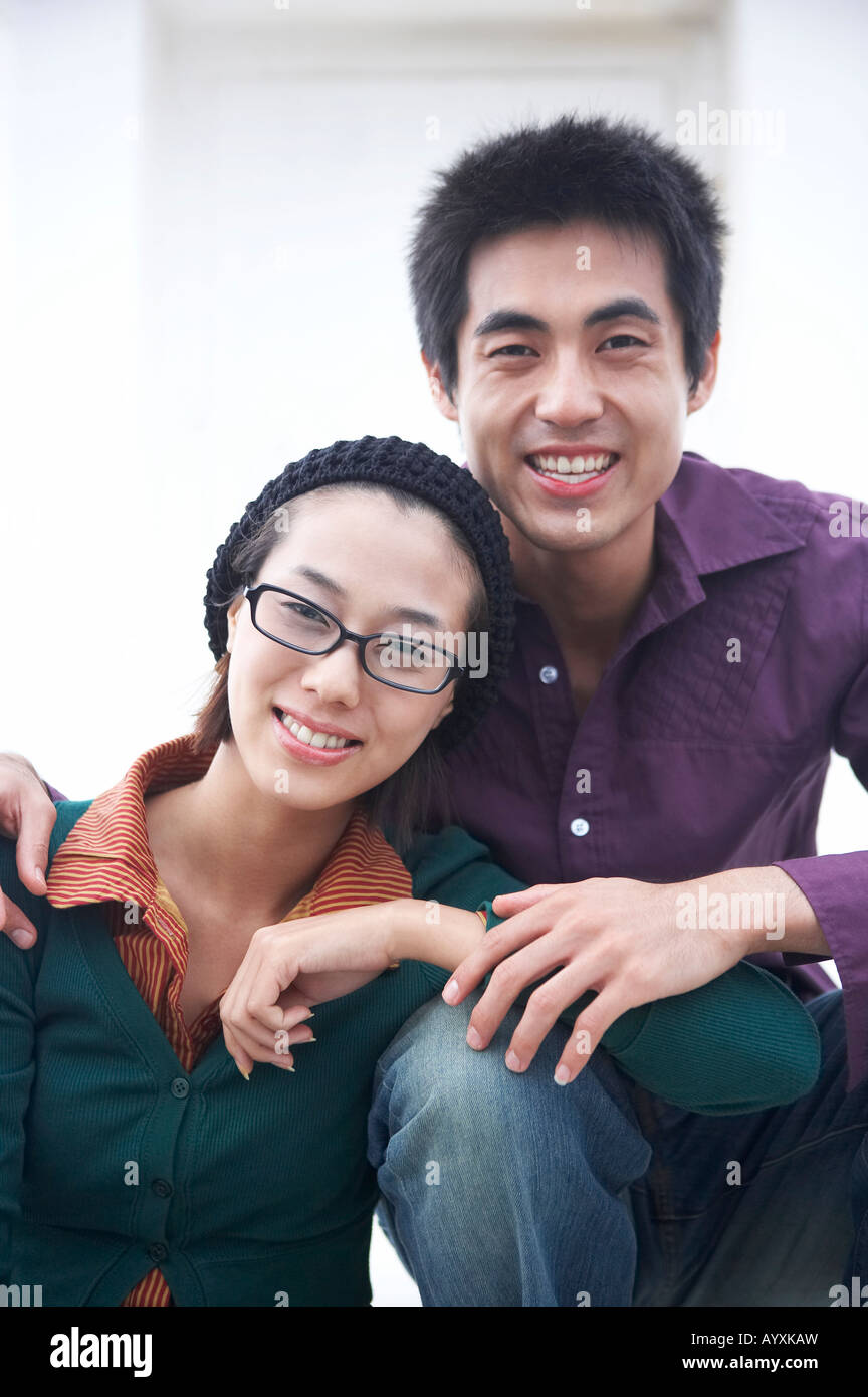 a couple smiling with putting arms around each other's shoulders and ...