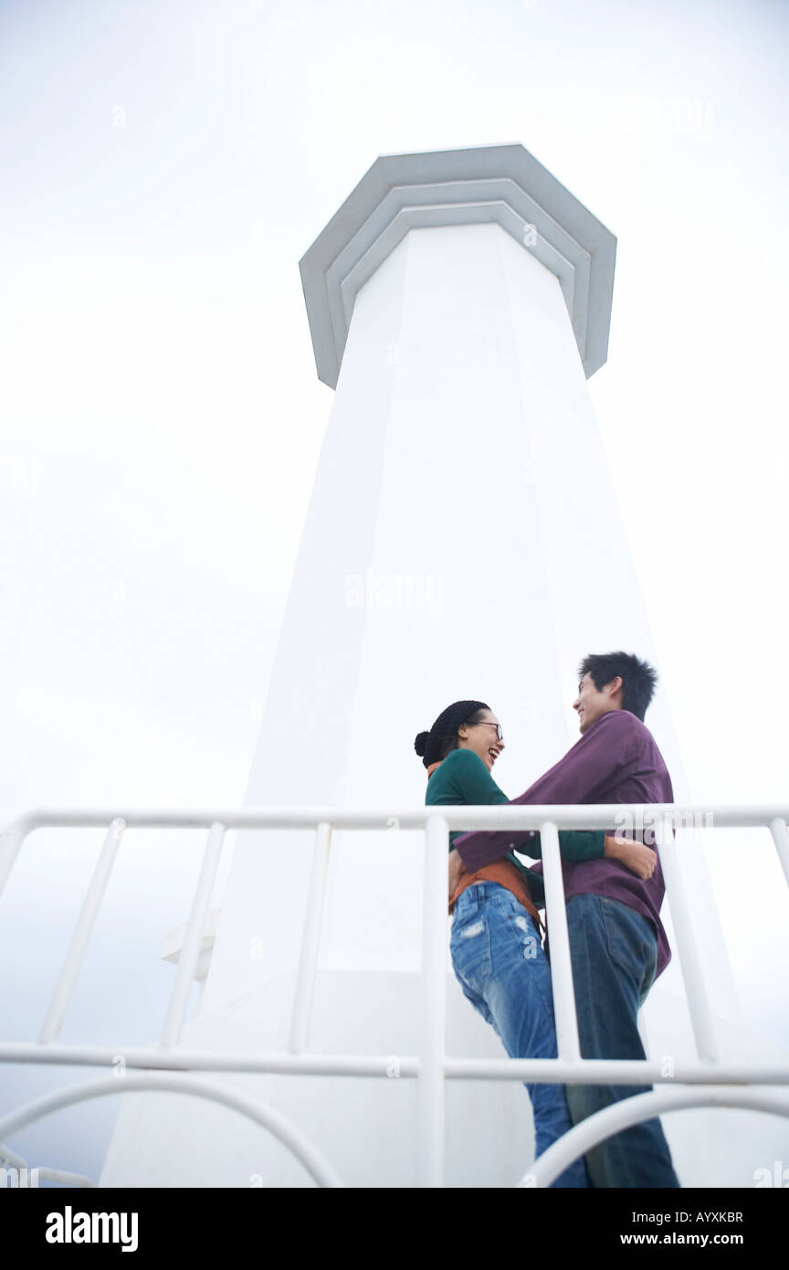 a couple smiling with facing each other and standing in the lighthouse ...