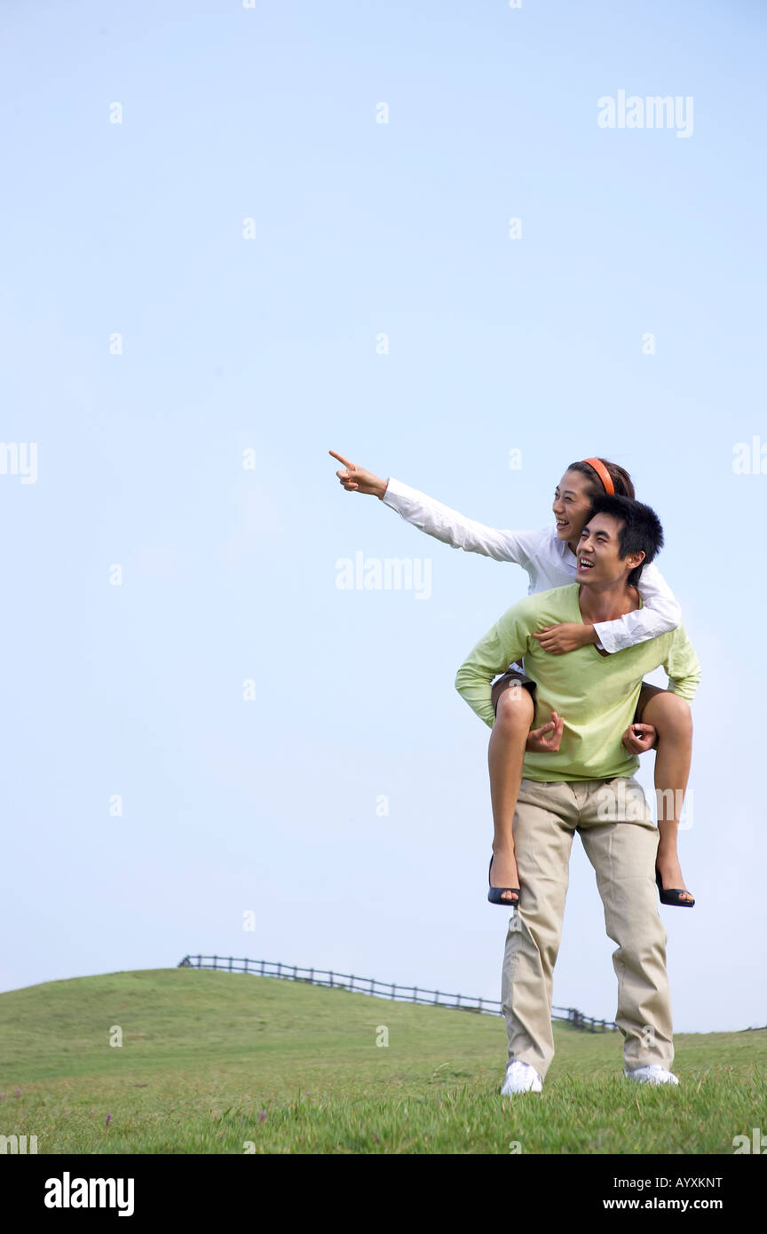 a man carring her on his back and a woman pointing out the sky in the ...