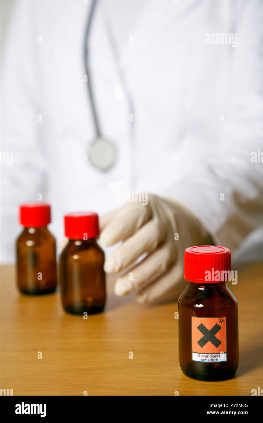 Brown flask with toxic liquids, person in background Stock Photo - Alamy