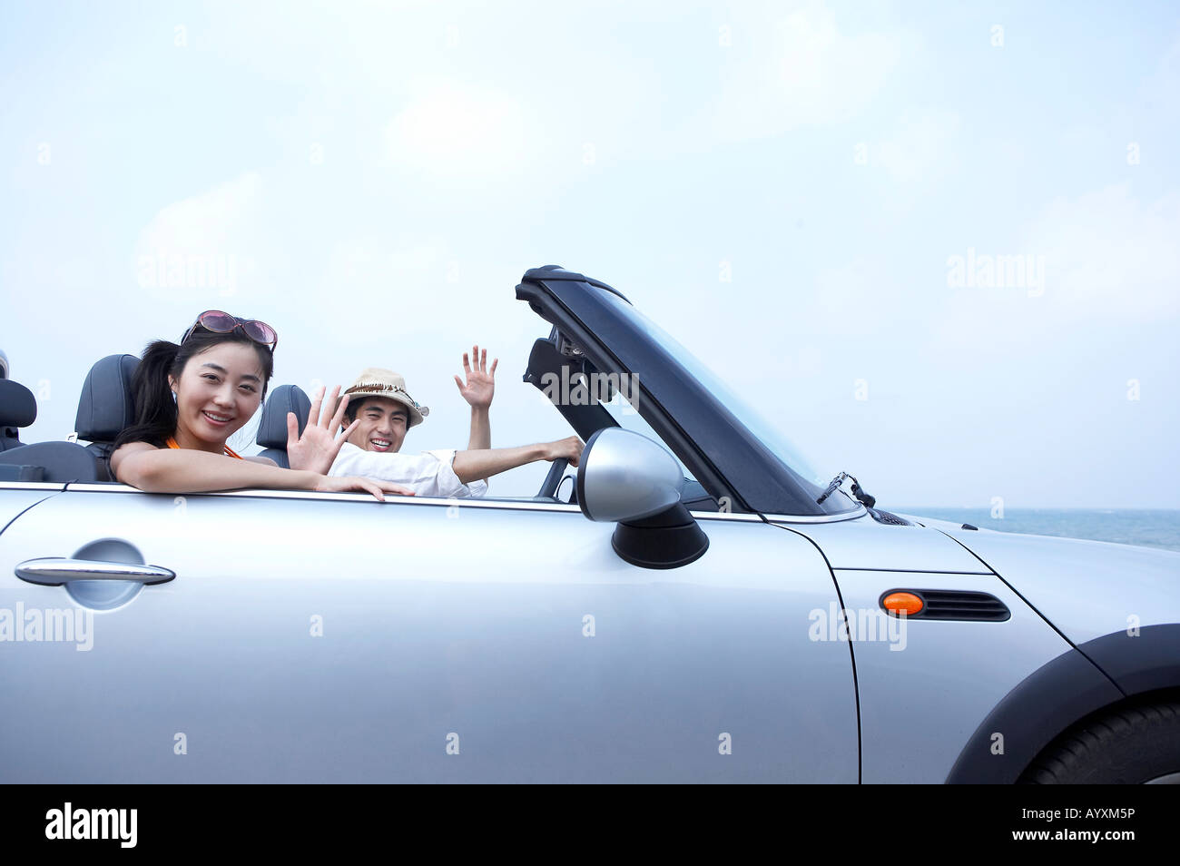 a couple enjoying with riding the sports car Stock Photo - Alamy