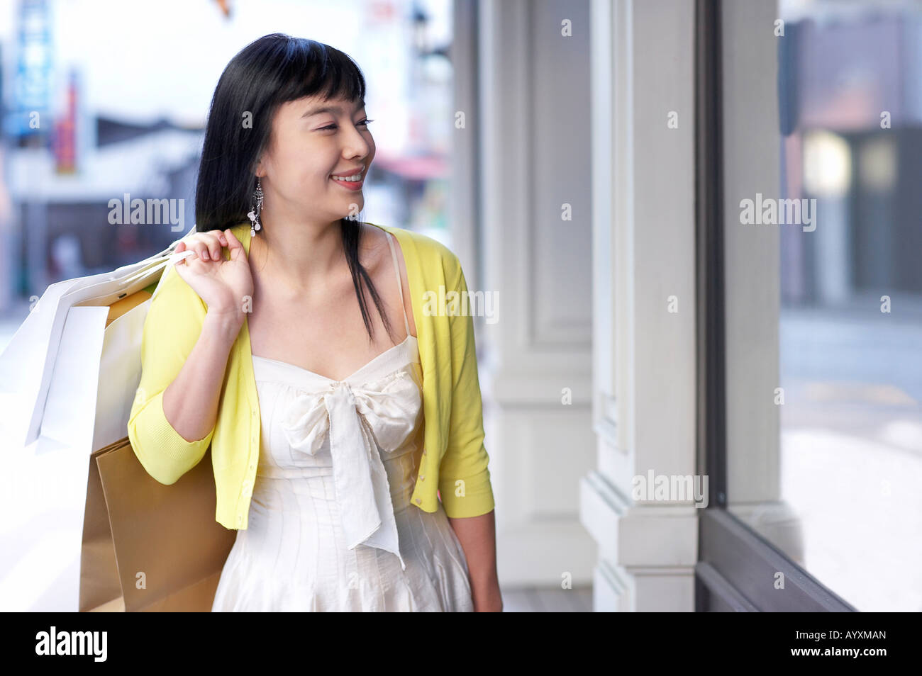 a woman seeing showwindow with holding a shopping bag Stock Photo - Alamy