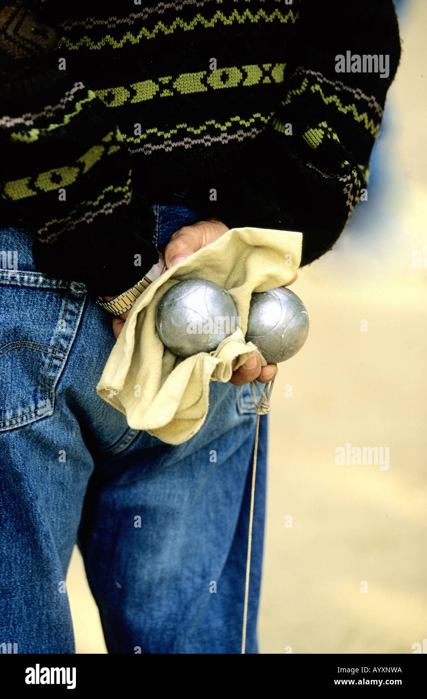 frenchman holding boules cradled in soft cloth behind his back with a ...