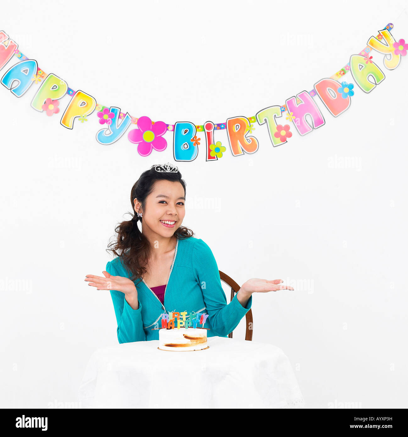 a woman sitting in table placed with birthday cake Stock Photo - Alamy