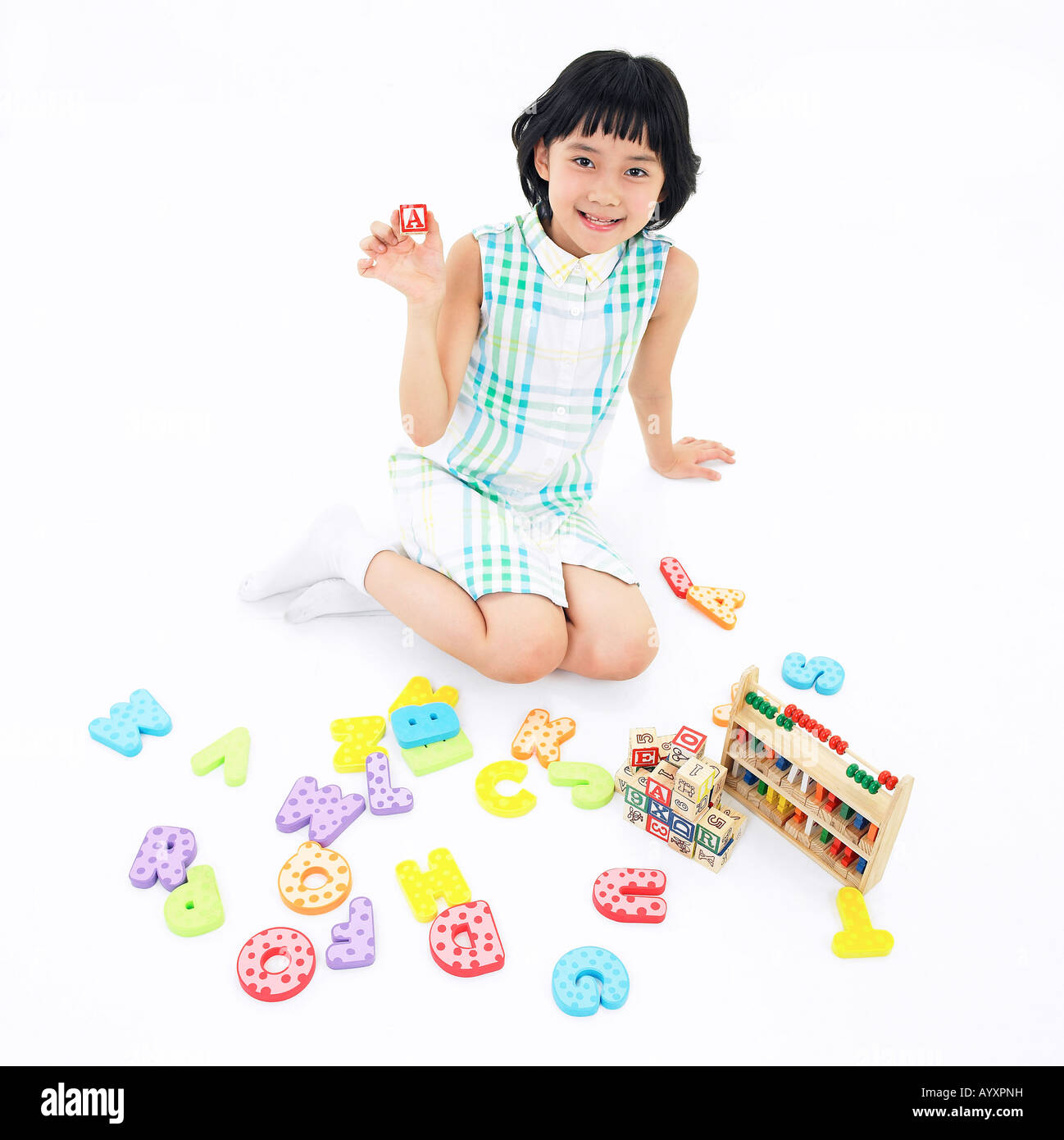 a girl holding alphabet block Stock Photo - Alamy