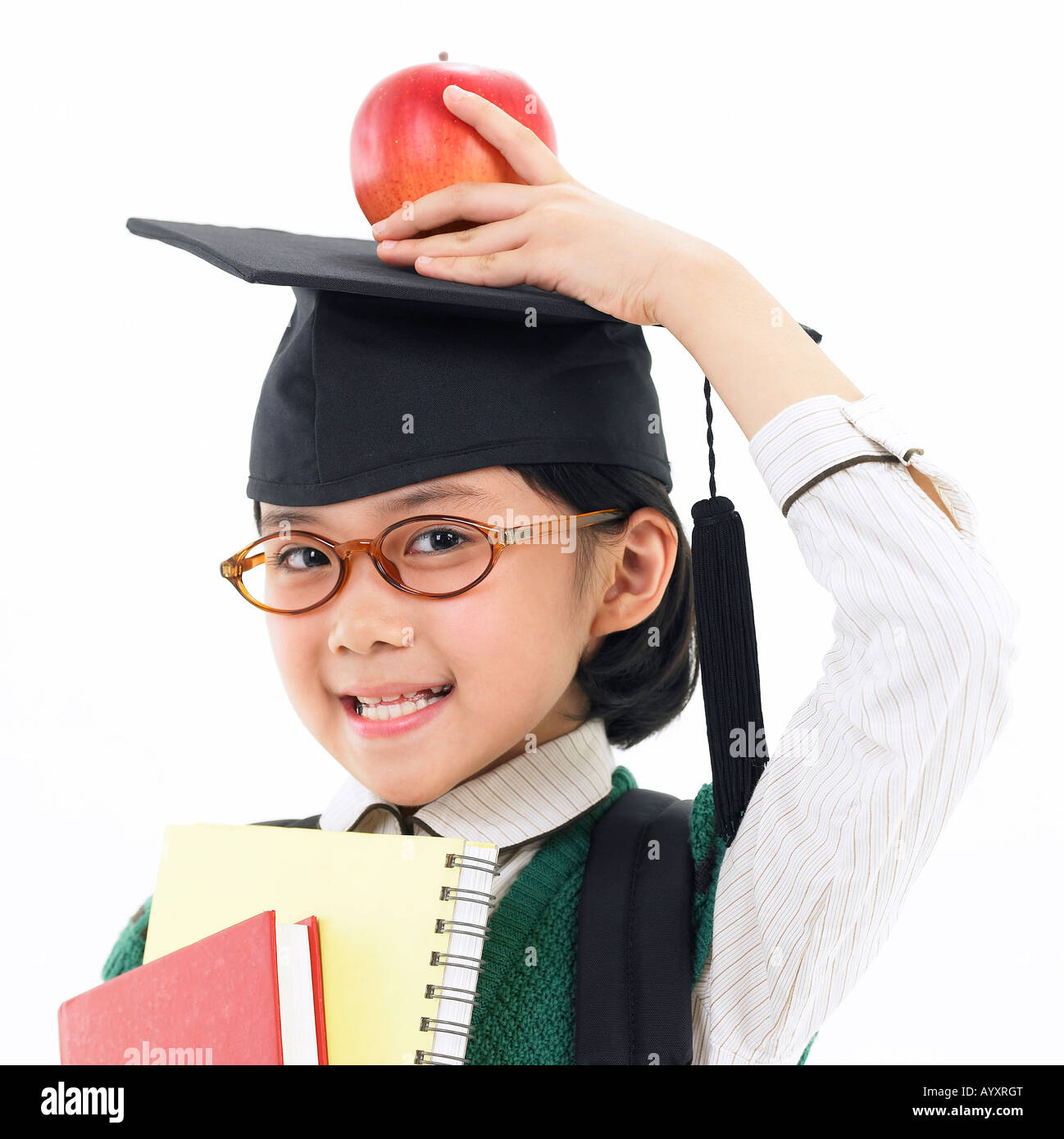 the girl putting a apple on graduation hat Stock Photo - Alamy