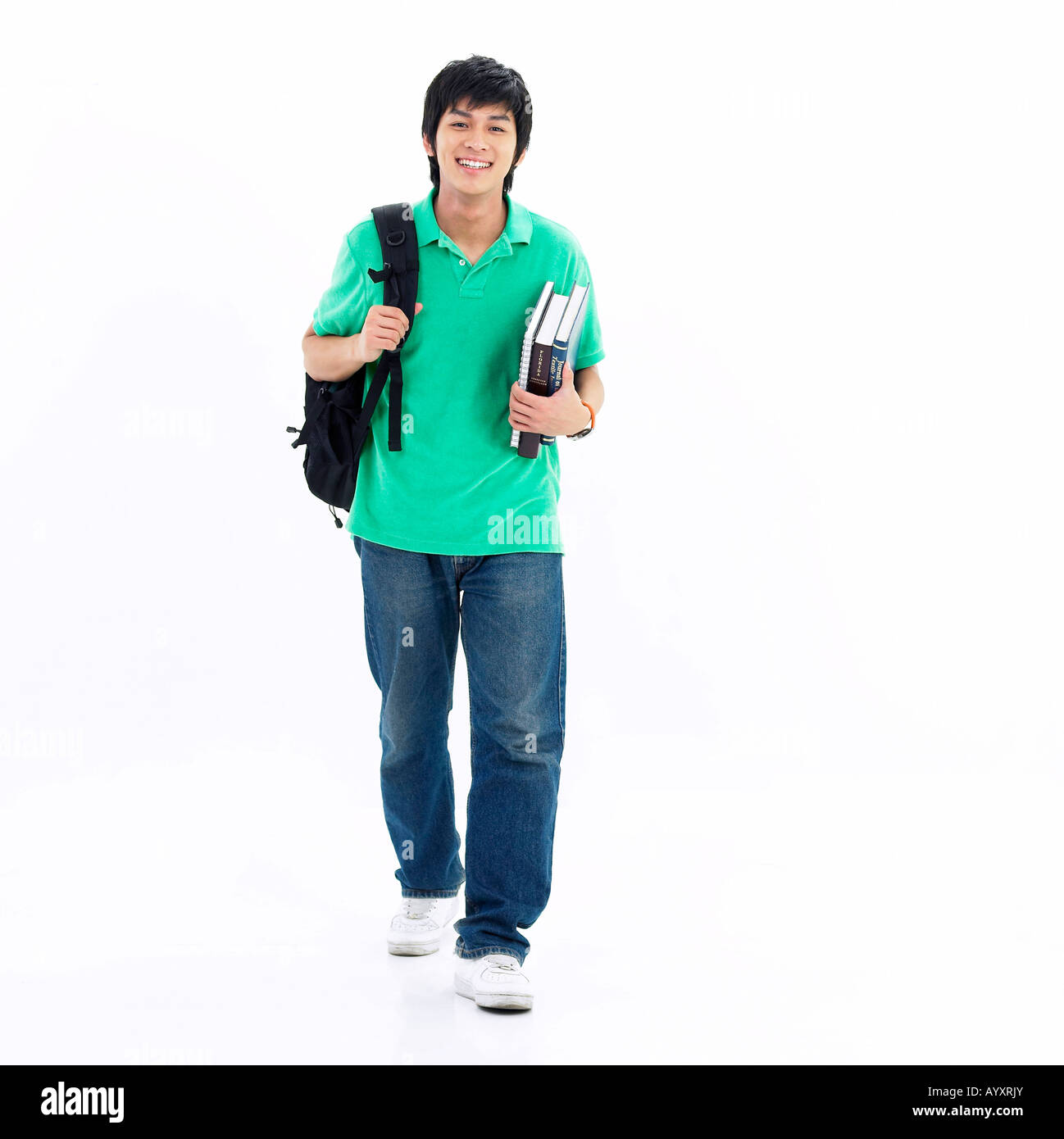 the boy student coming with holding a book bag and a book Stock Photo ...