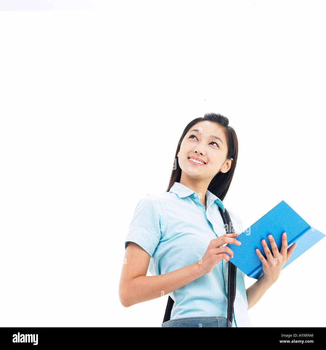 a girl student looking at the sky with holding a opened book Stock ...