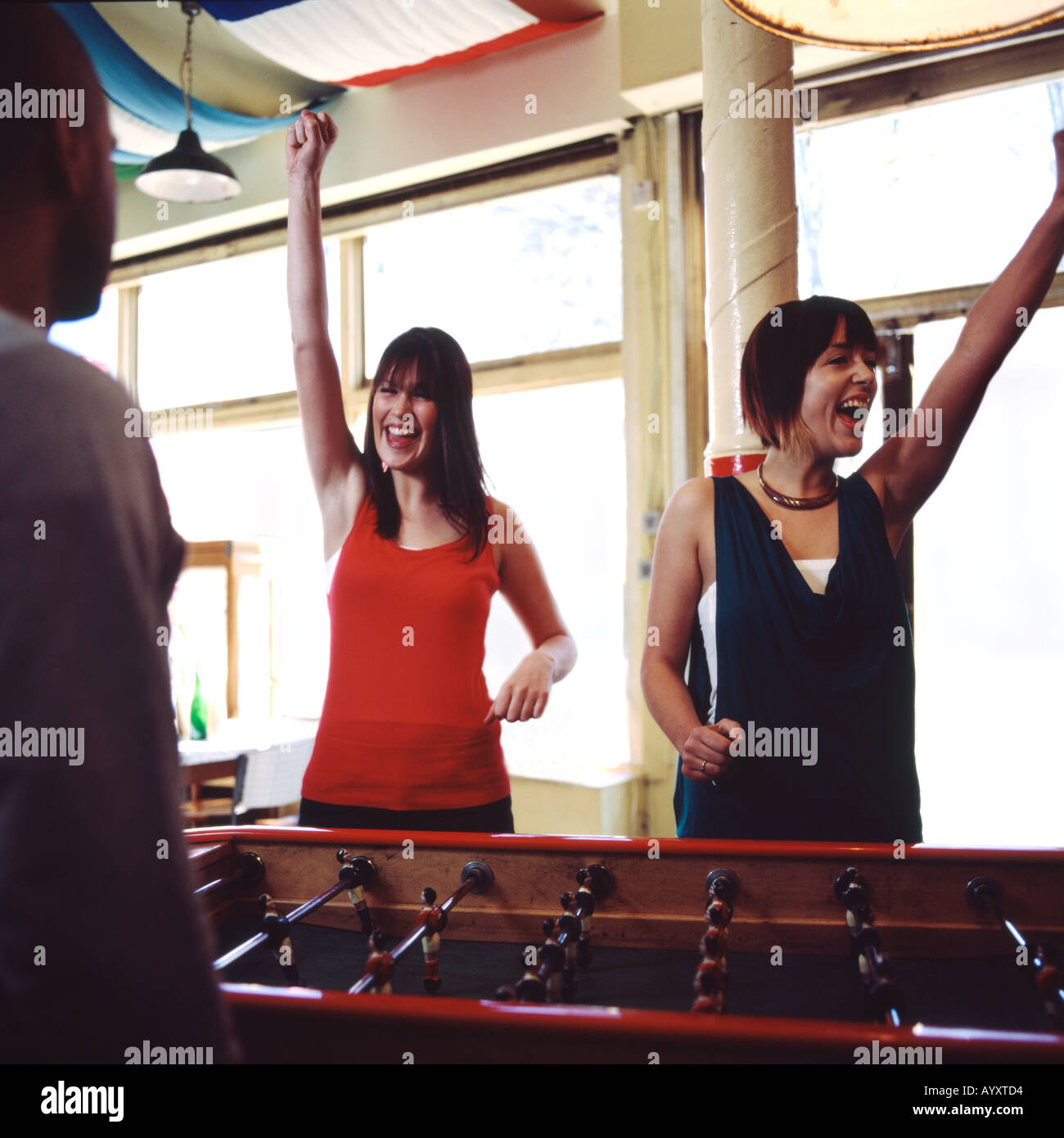 Girls beating boys at table football Stock Photo - Alamy