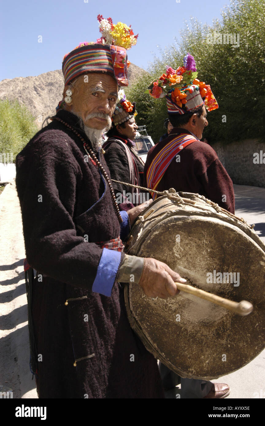 Traditional dress Brokpa or Dard tribe man with flowers and drum during ...