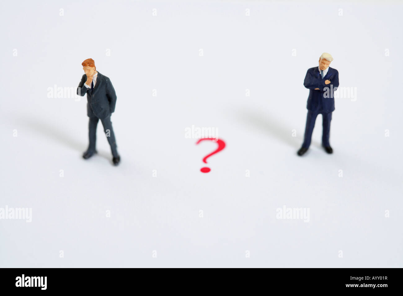 Question mark between businessmen figurines Stock Photo - Alamy