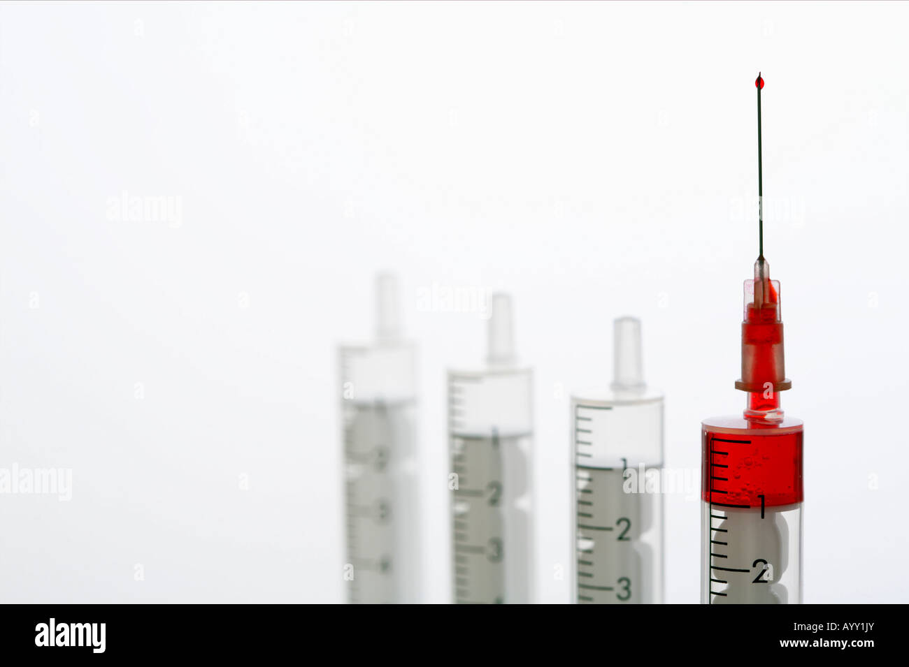 Four syringes in a row, on filled with red liquid Stock Photo - Alamy