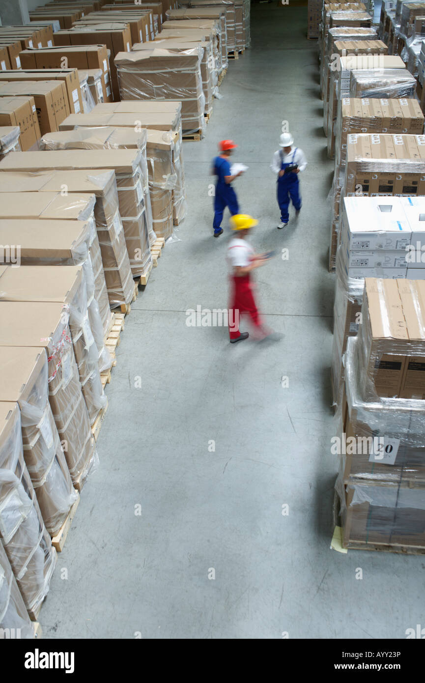 Three people in a warehouse Stock Photo - Alamy