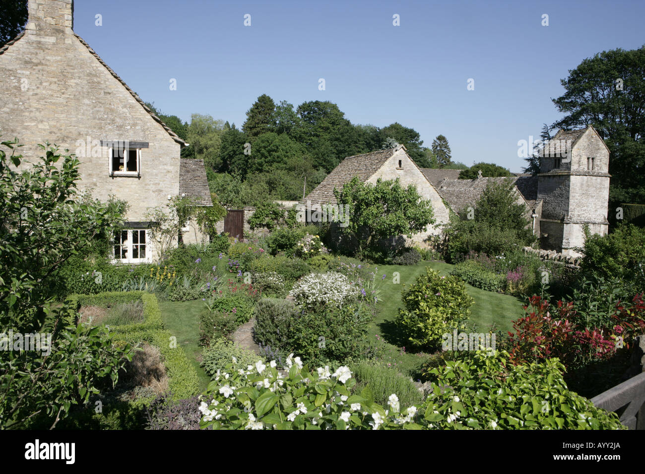 A cottage and village church at Bagendon in the Cotswolds Stock Photo ...