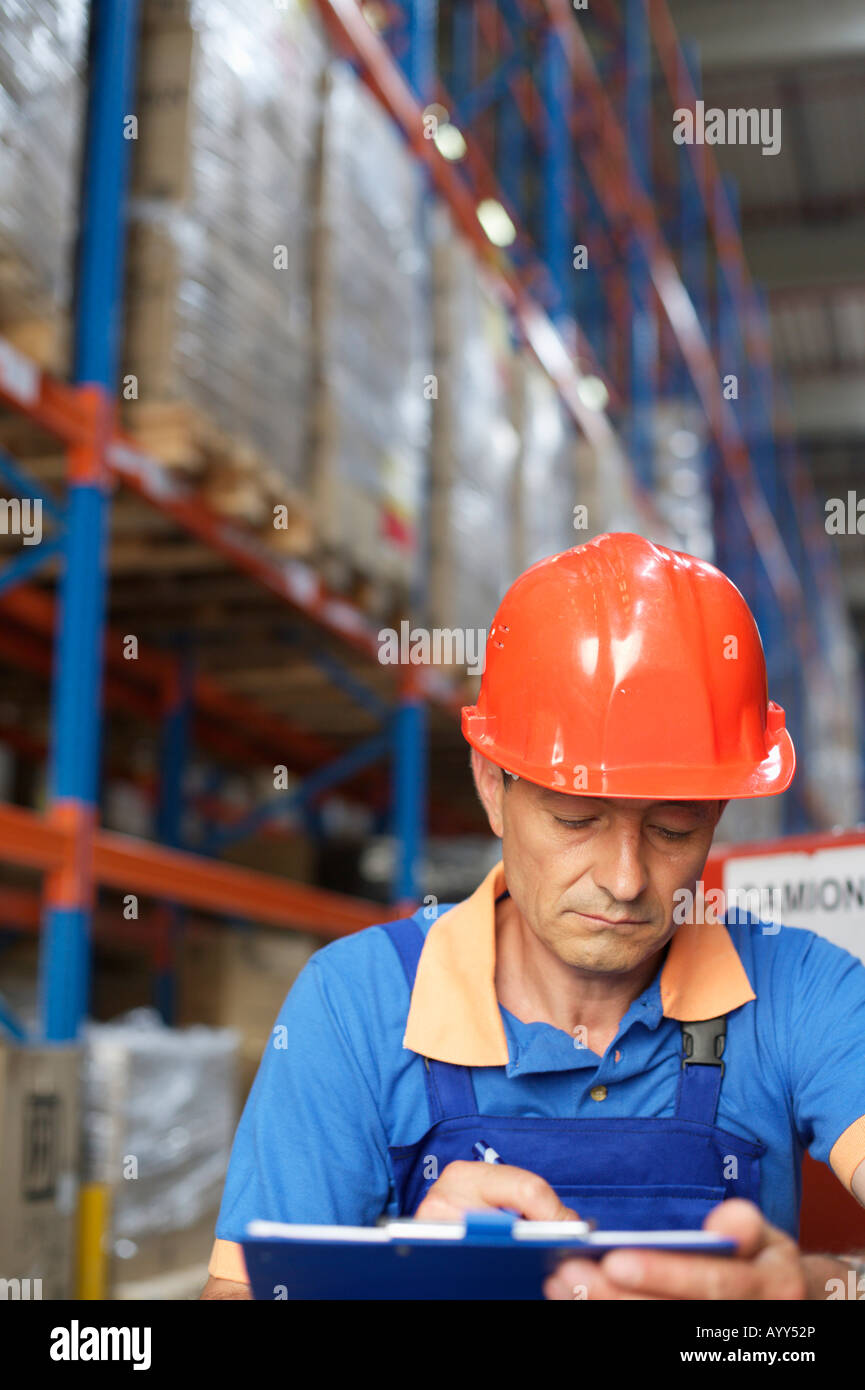 Worker writing on a clipboard Stock Photo - Alamy