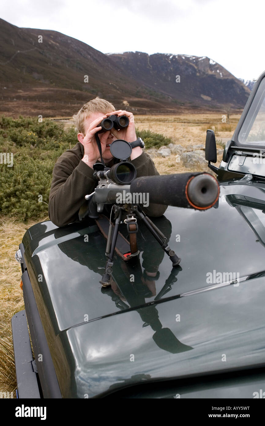 Alladale stalker David Clark watching red deer beside Land Rover ...