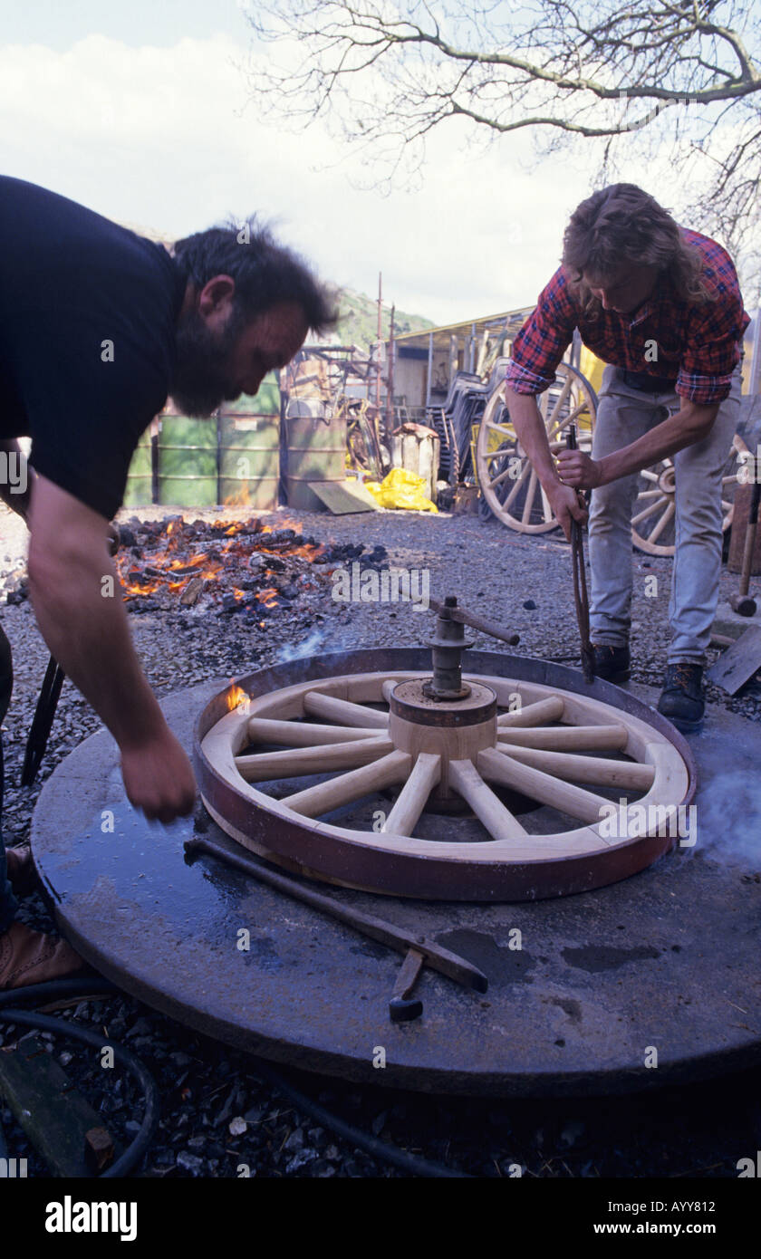 Wheelwright's at work ( tyring the wheel ) putting a metal hoop around ...