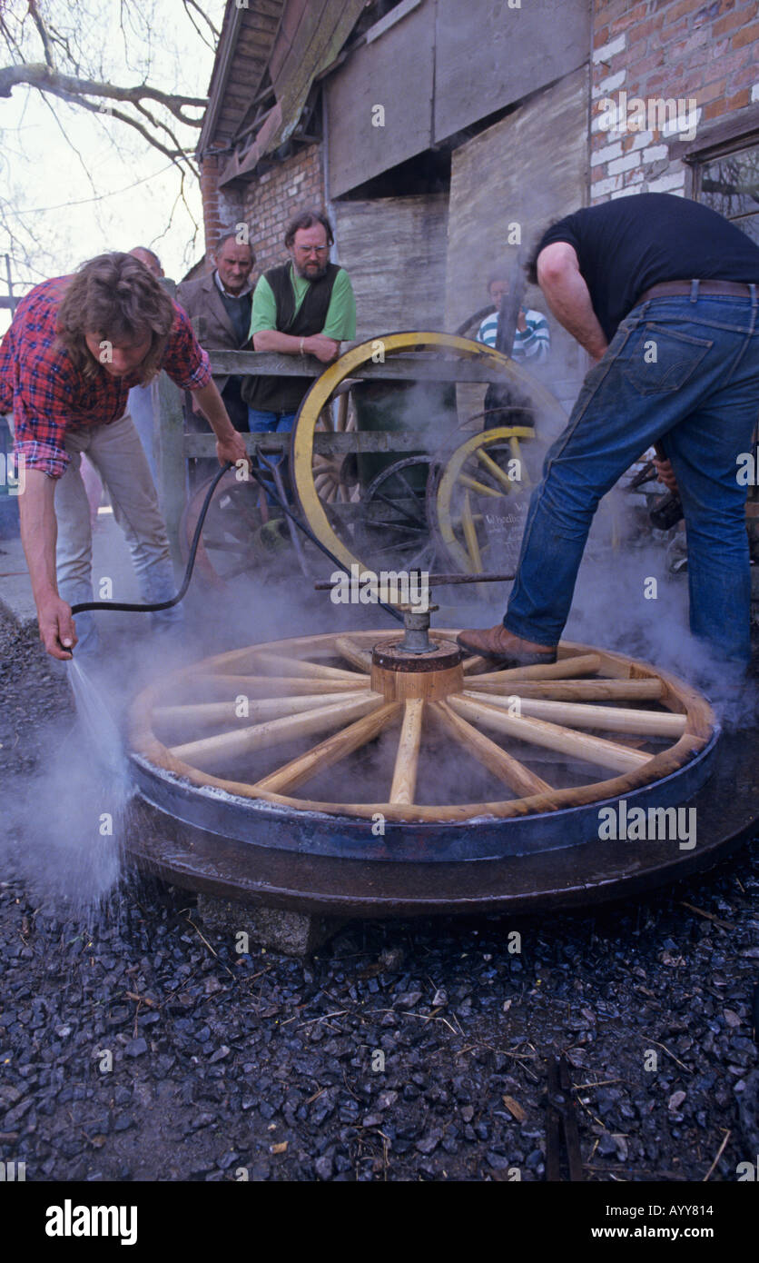Wheelwright's at work ( tyring the wheel ) putting a metal hoop around ...