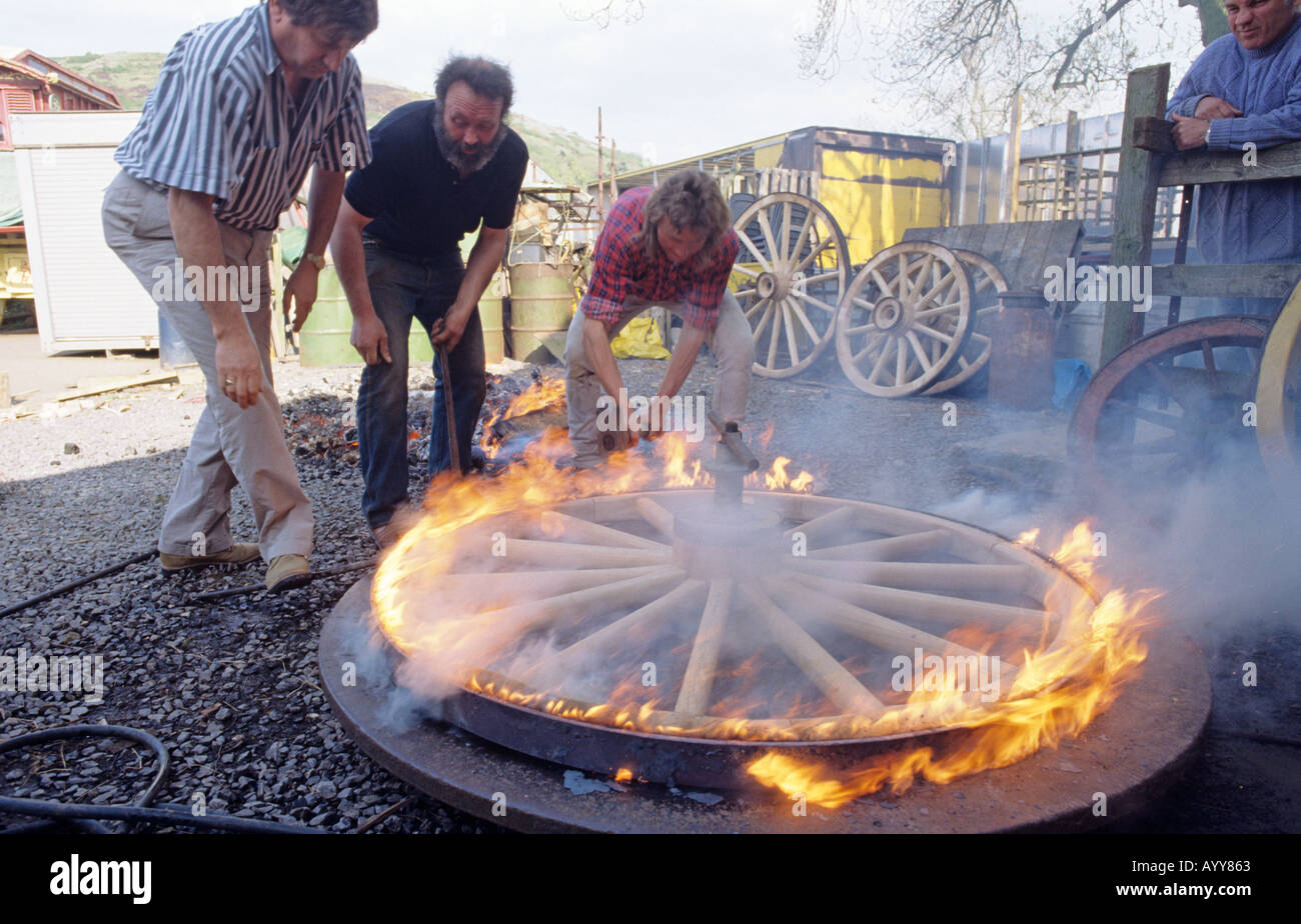 Wheelwright's at work ( tyring the wheel ) putting a metal hoop around ...