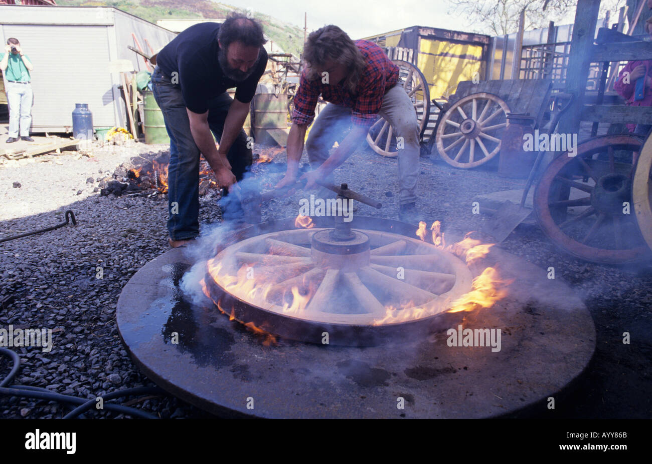 Wheelwright's at work ( tyring the wheel ) putting a metal hoop around ...