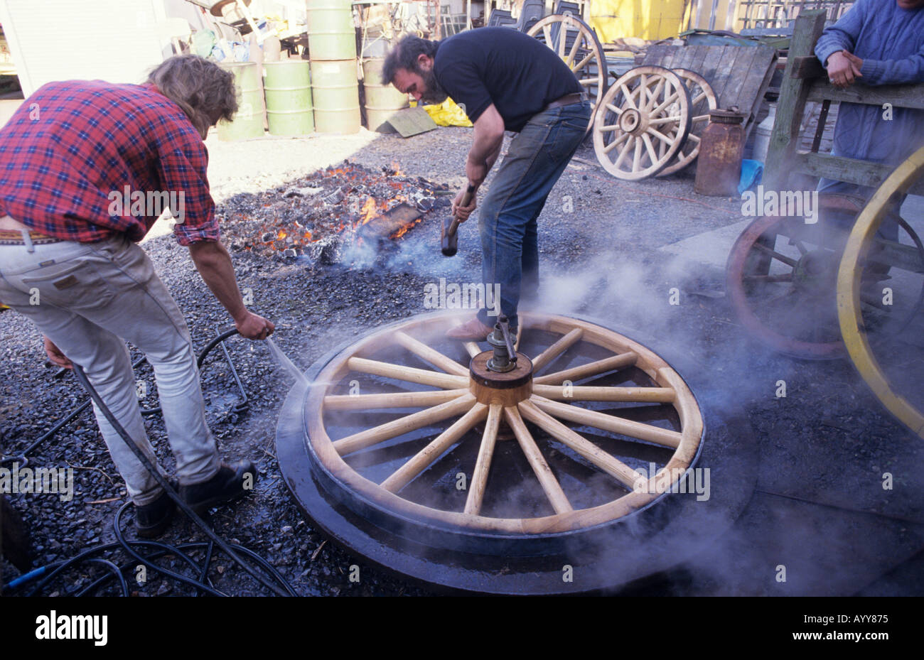 Wheelwright's at work ( tyring the wheel ) putting a metal hoop around ...