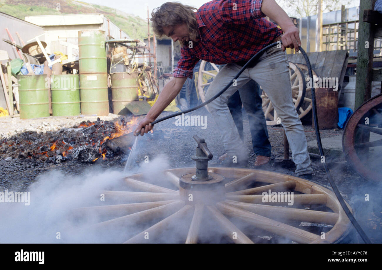 Wheelwright's at work ( tyring the wheel ) putting a metal hoop around ...