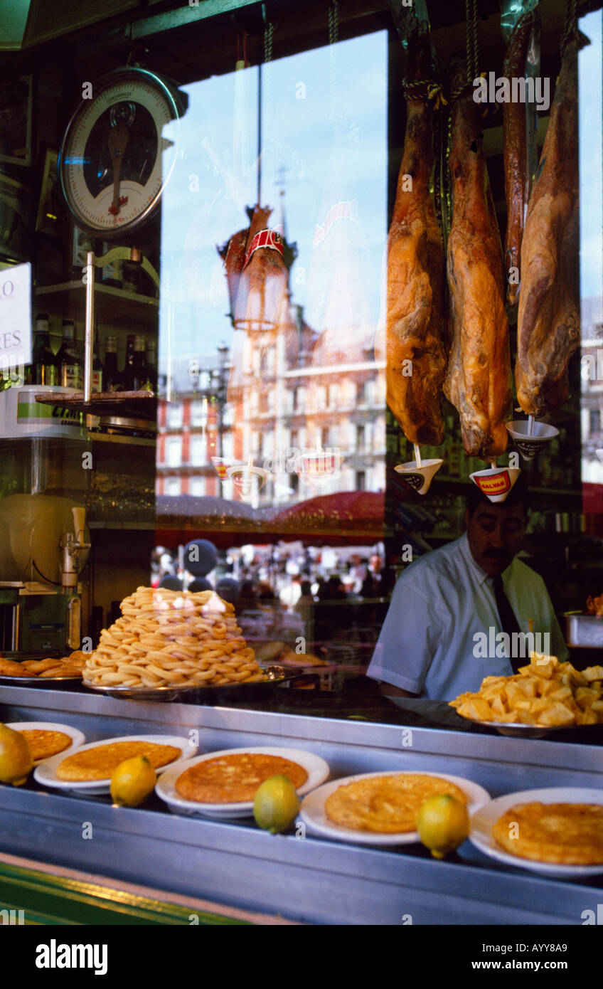 Hams hang above a food counter in the window of a restaurant in the ...
