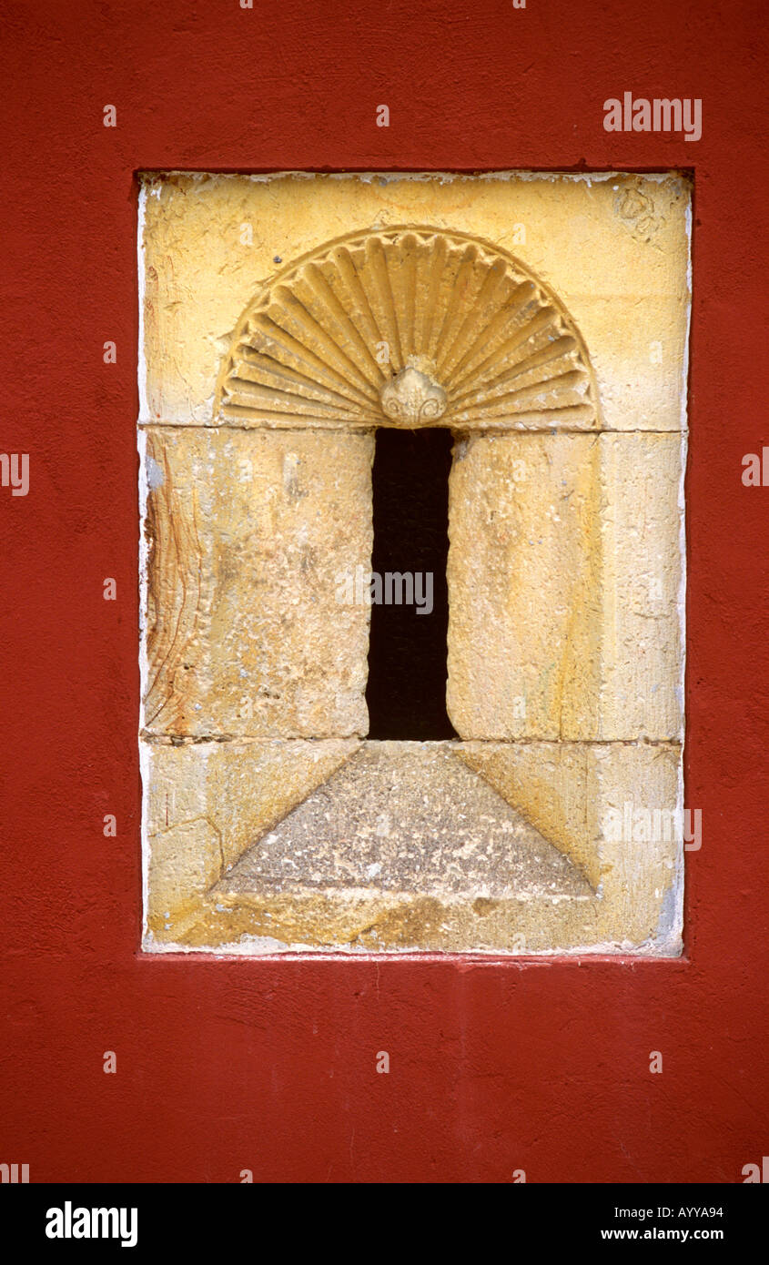 An old stone alcove is framed by a red painted wall in a mansion in ...