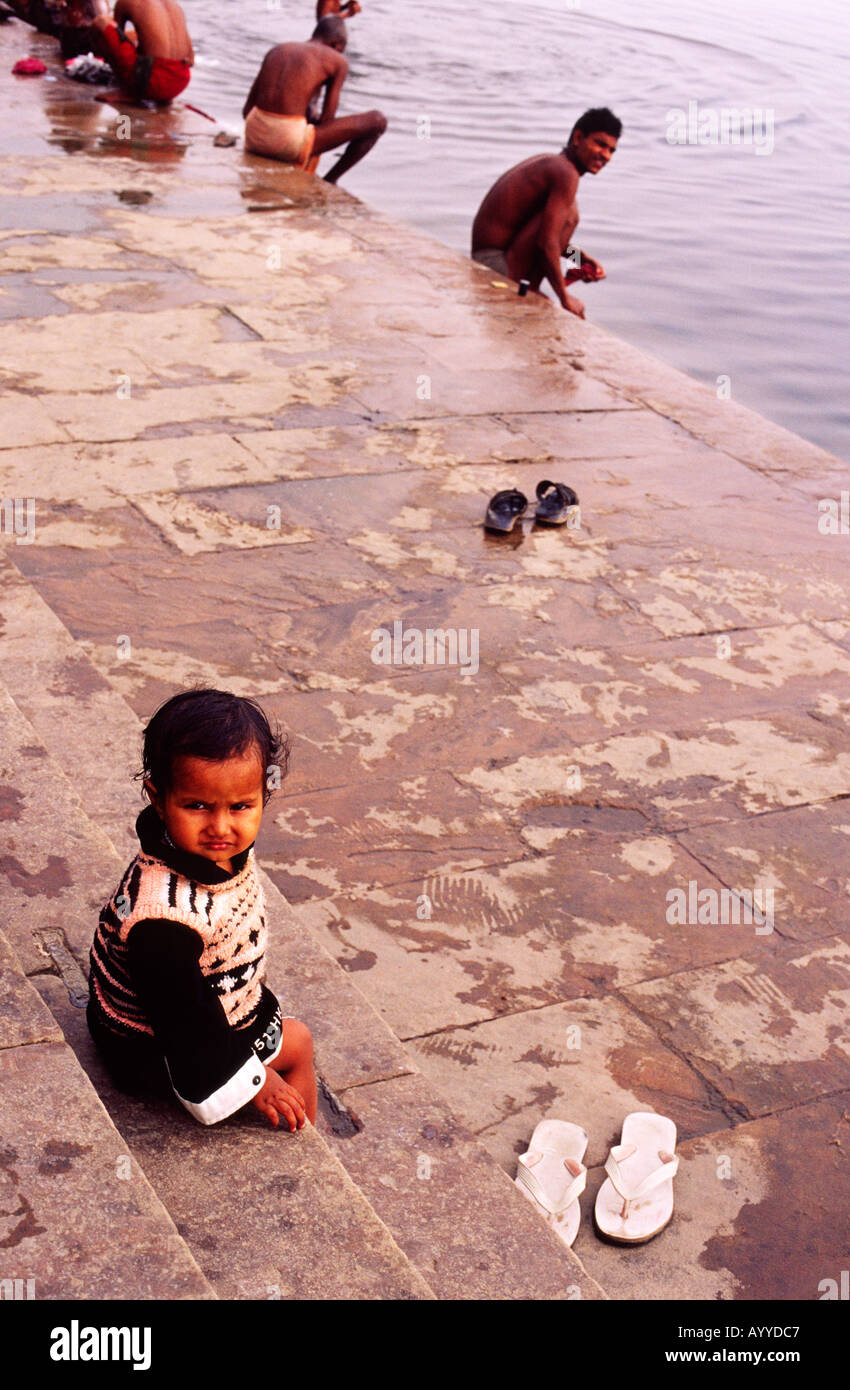 Young boy in foreground people bathing and washing clothes on the edge ...