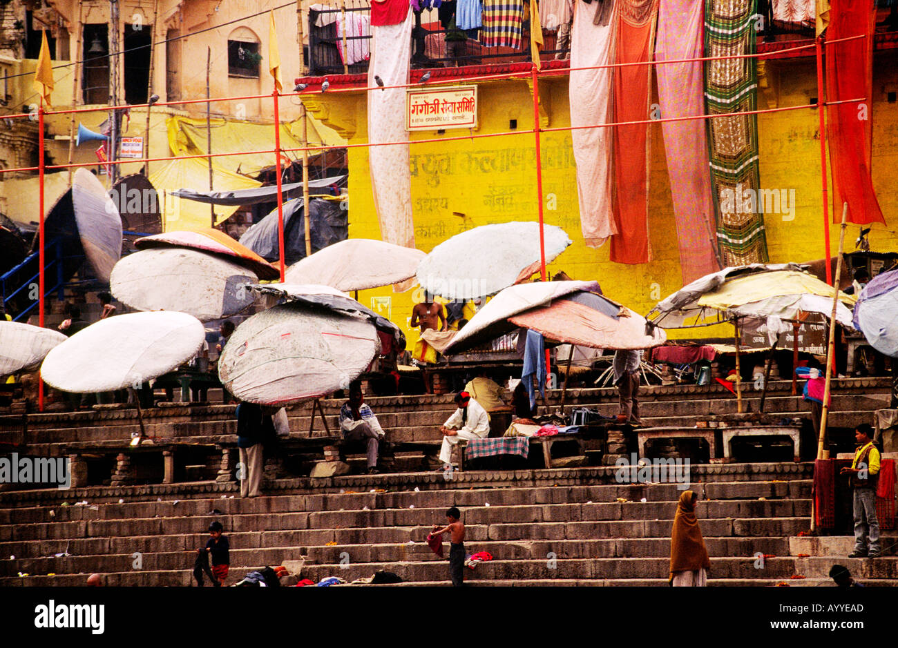 Ghat steps leading to Ganges River Varanasi market under many umbrellas ...