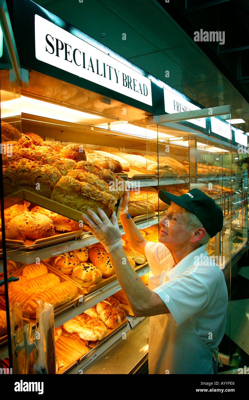 Baker loads bread into shelves at a Supermarket Stock Photo - Alamy