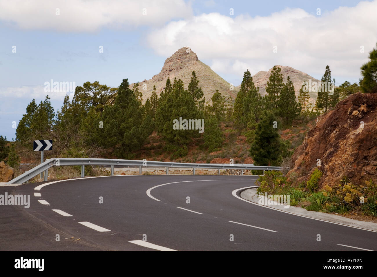 Empty curved road near a mountain Stock Photo - Alamy