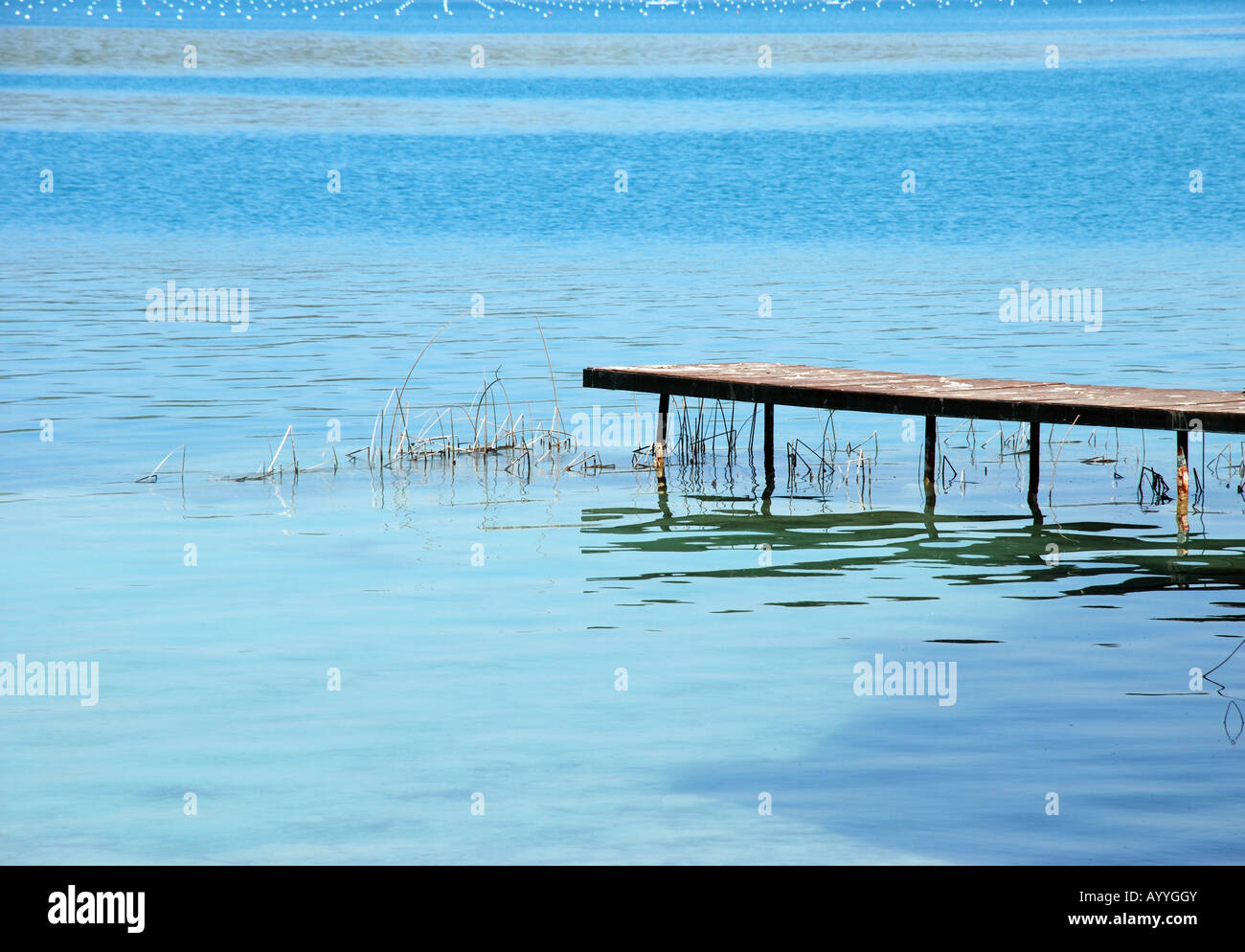An small quay on the blue waters of the Banyoles lake Stock Photo - Alamy