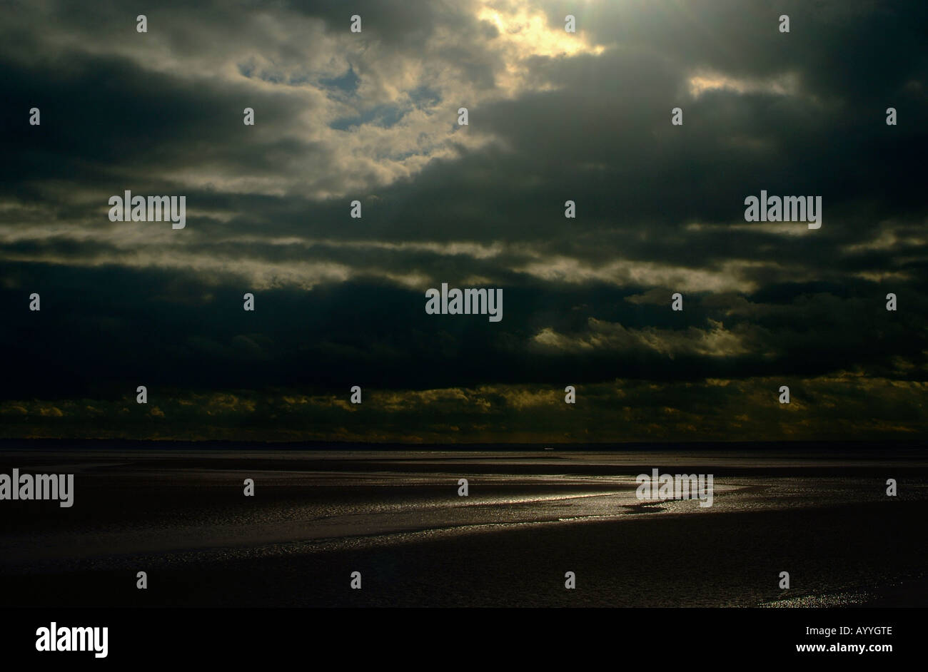 A storm passes over sandbanks in the Thames estuary as the tide goes ...