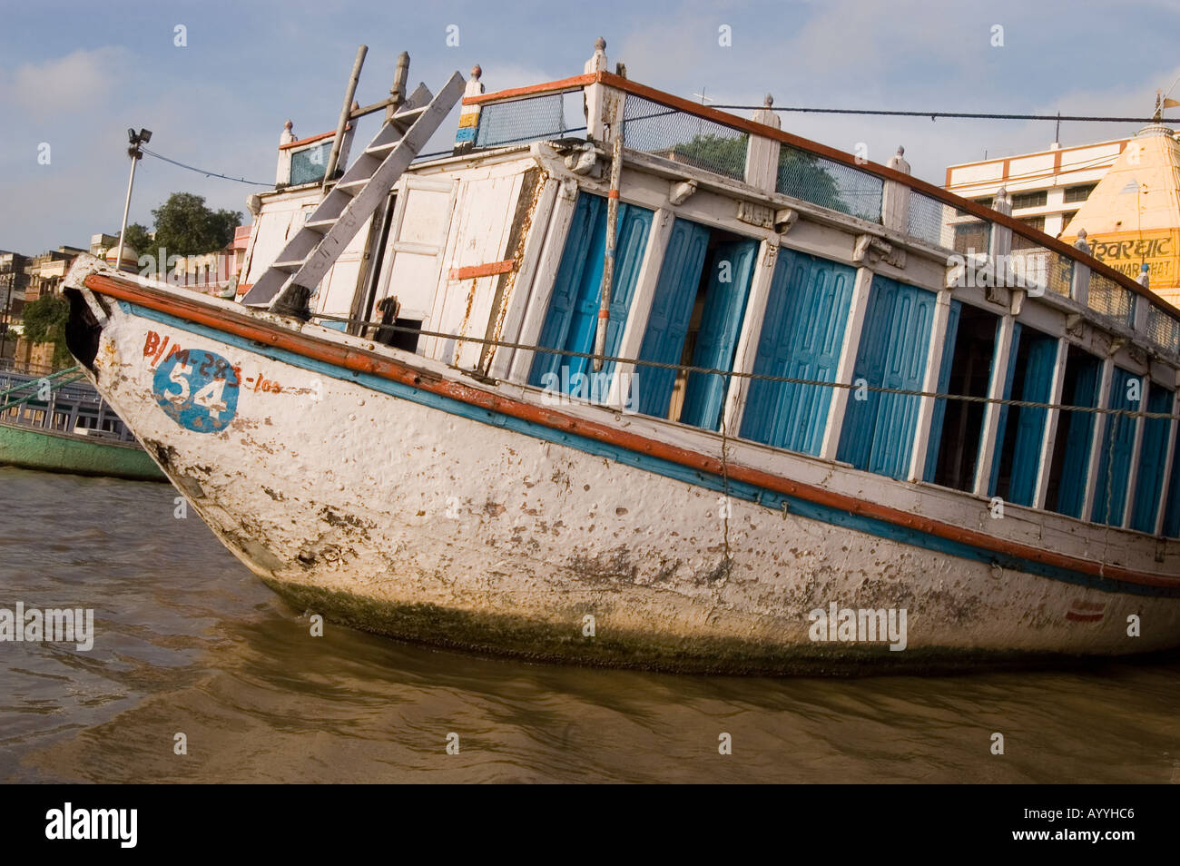 Old tourist boat at ghat on the bank of Ganges River at sunrise ...