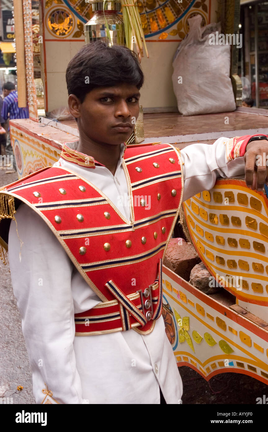 Uniformed Indian boy with chariot in the background looking at camera ...
