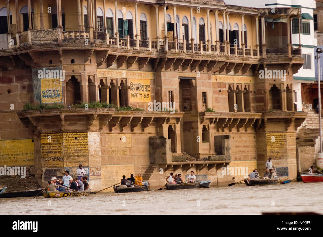 Boat with tourists sailing near old ghat in the bank of Ganges River ...