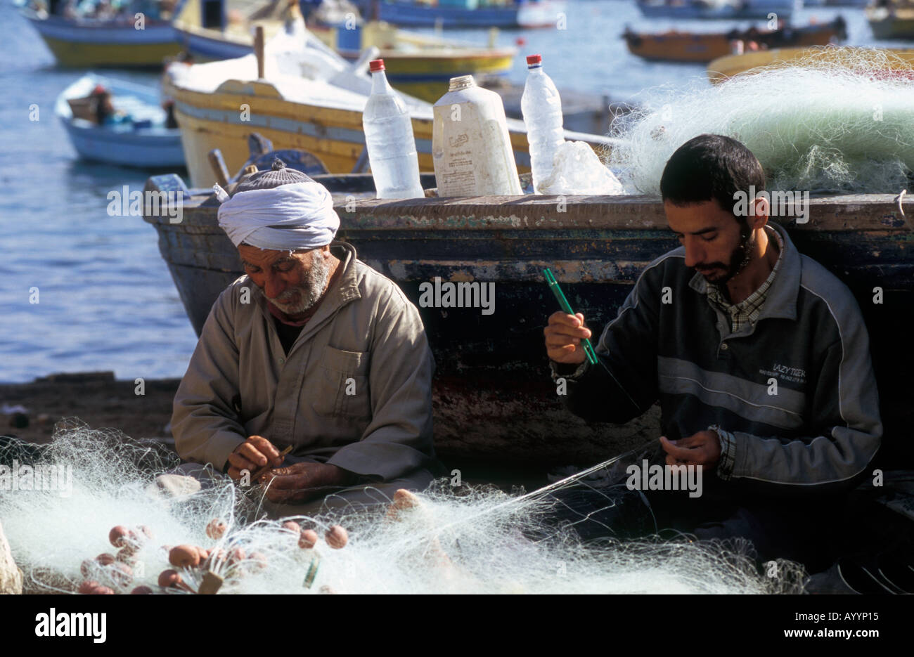Fishermen mending their nets in the port of Alexandria Egypt Stock ...