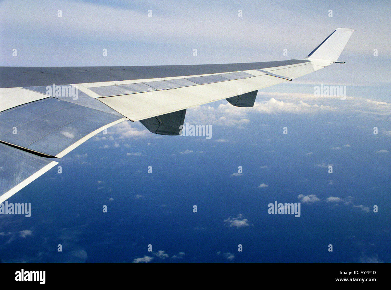 Wing and cloud formations viewed through the window of a jet airliner ...