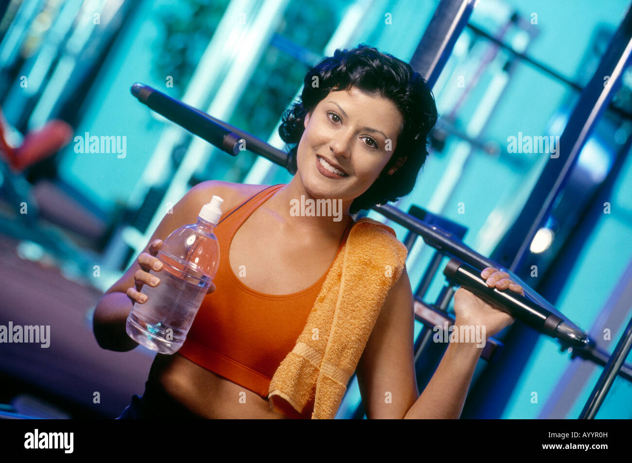 Female with water working out at gym, holding water bottle for staying ...