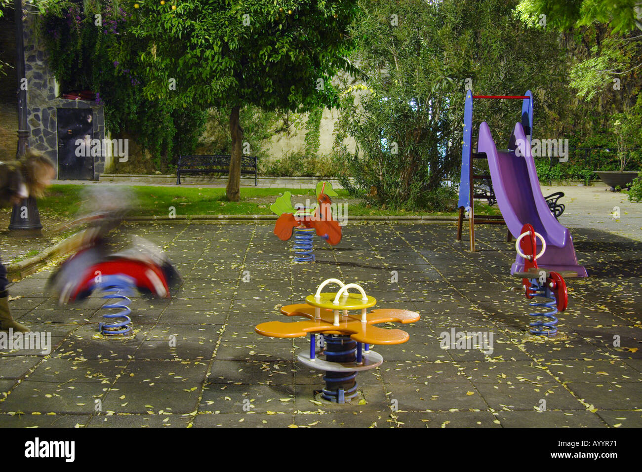 Night shot of a child playing in a playground Stock Photo - Alamy