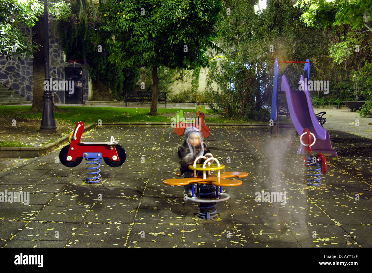 Night shot of a child playing in a playground Stock Photo - Alamy