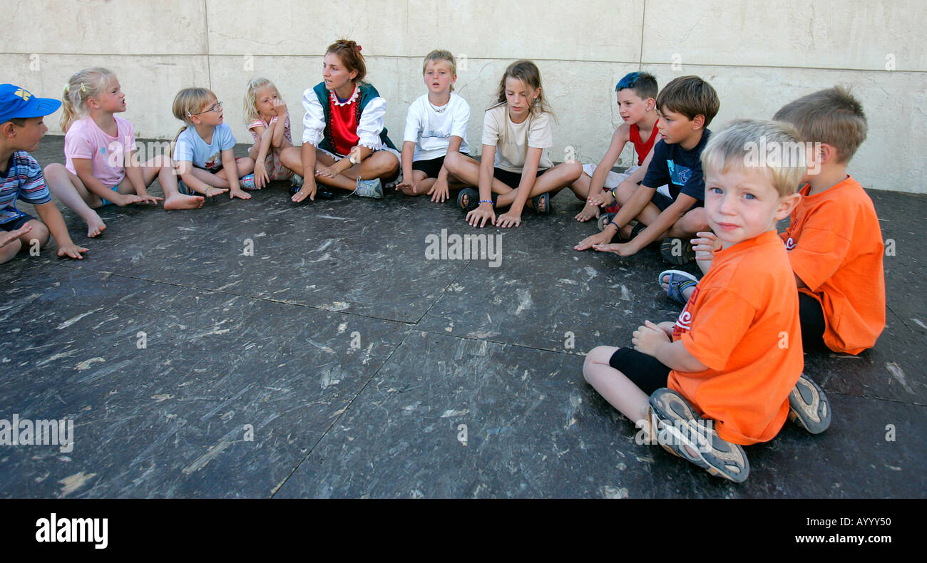 Group of children playing with supervisor children boy girl infant sand ...
