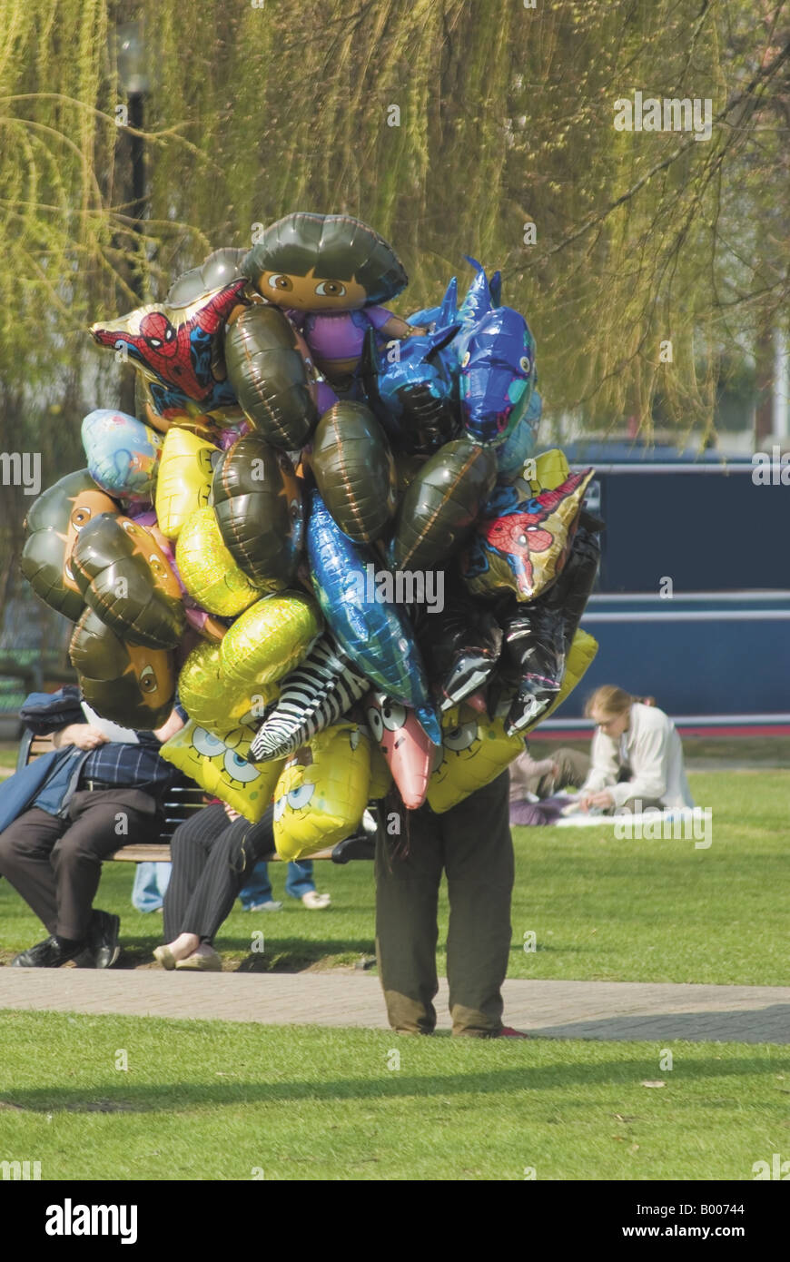 man selling balloons walking through park Stock Photo - Alamy