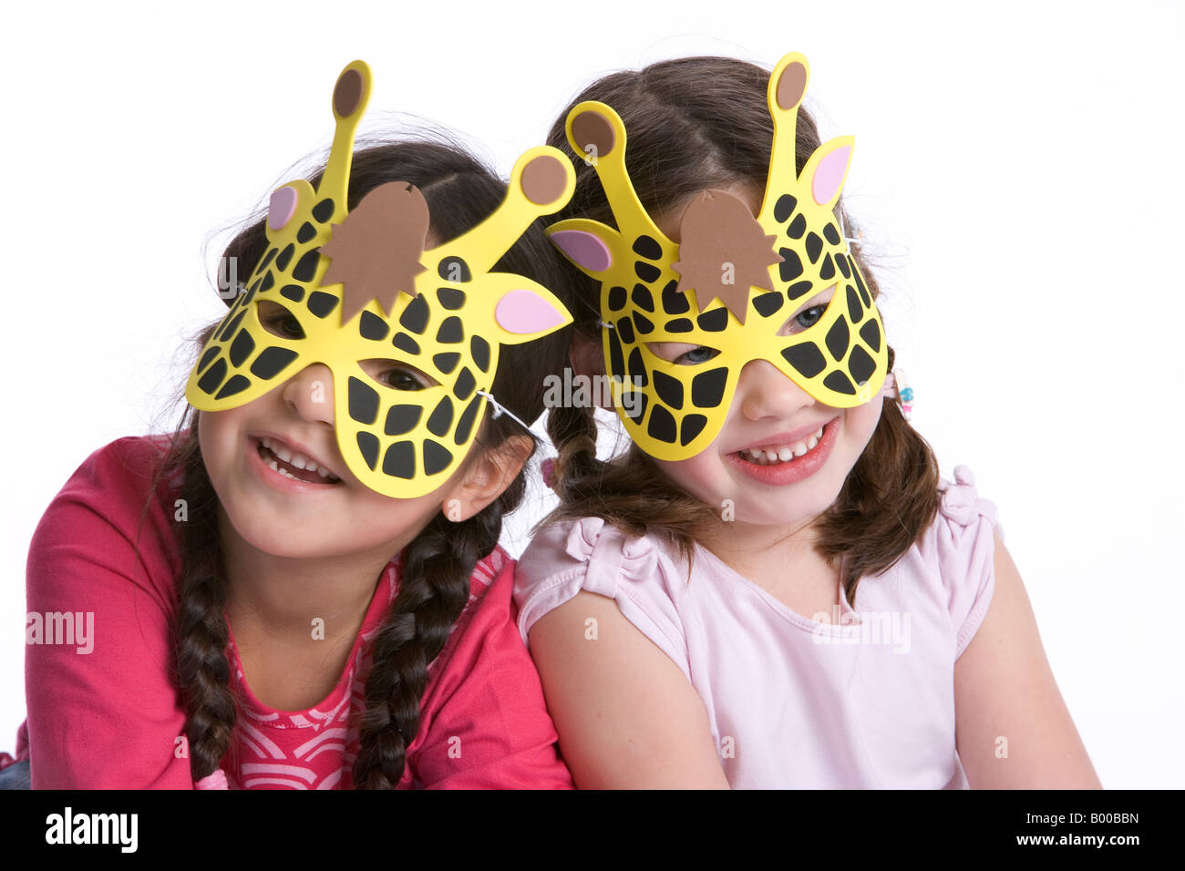 Two girls with a giraffe mask Stock Photo - Alamy