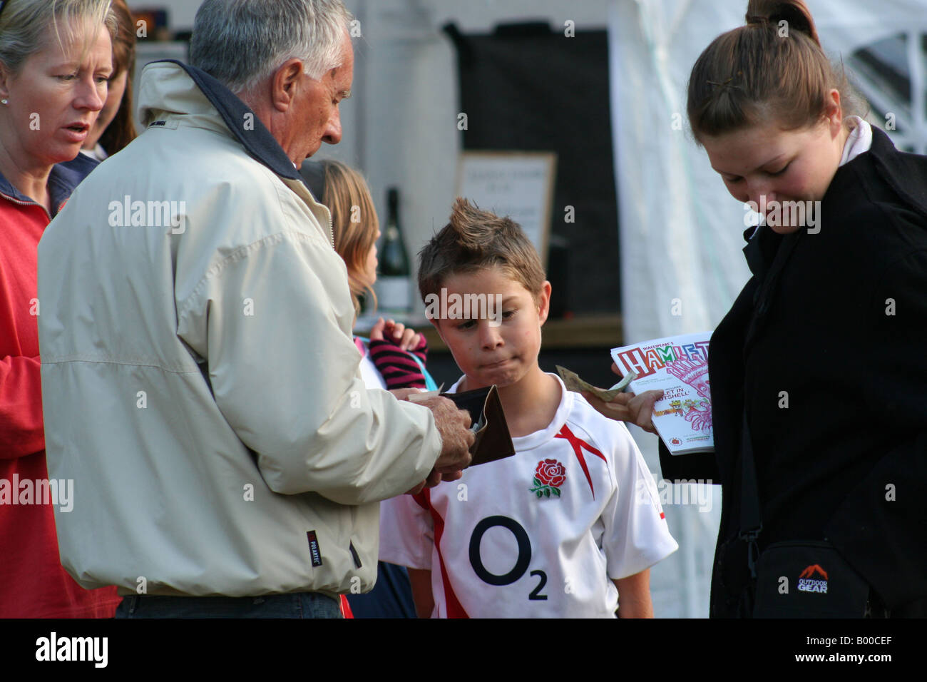 Family group buy a programme at an outdoor production of Hamlet Stock ...